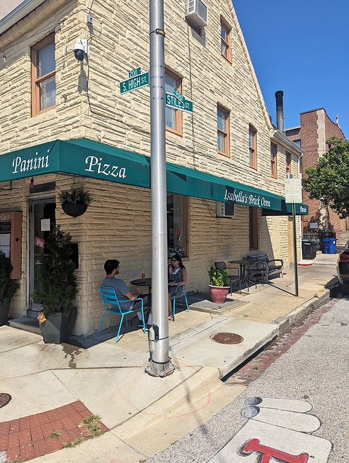 Stone building, green awnings, European charm. Isabella's corner spot feels like stumbling upon a secret pizza garden in Little Italy.