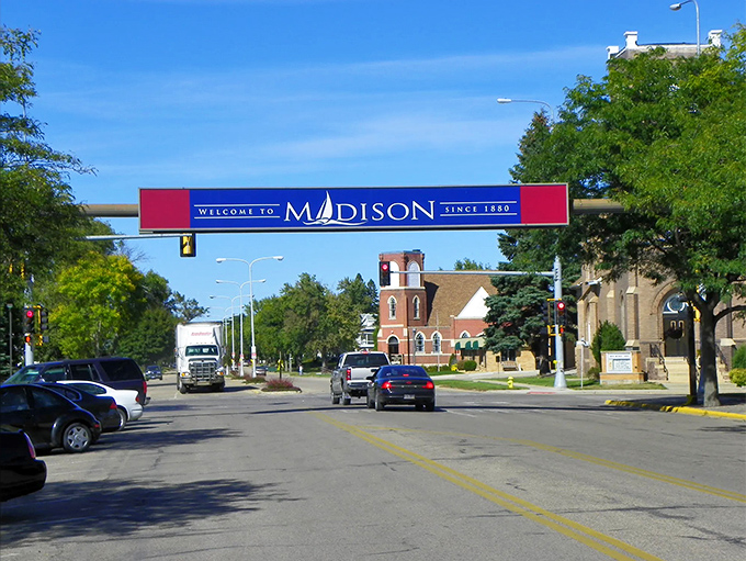 Madison's welcoming entrance sign spans the main street, greeting visitors to this charming South Dakota town established in 1880.