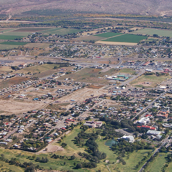 Socorro's aerial view showcases its picturesque setting along the Rio Grande, with green spaces dotting this affordable college town.