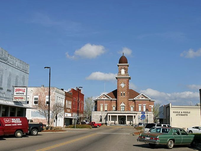 Greenville's historic downtown buildings stand tall against blue Alabama skies. Brick facades tell stories of businesses that have served generations.