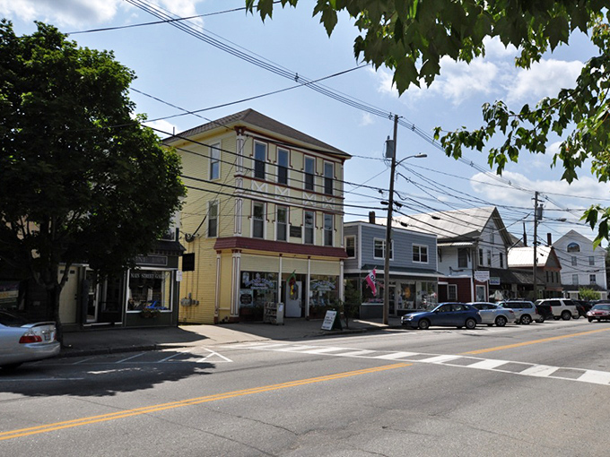 Sunlight bathes the historic buildings in a golden glow, highlighting architectural details from a more modest era.
