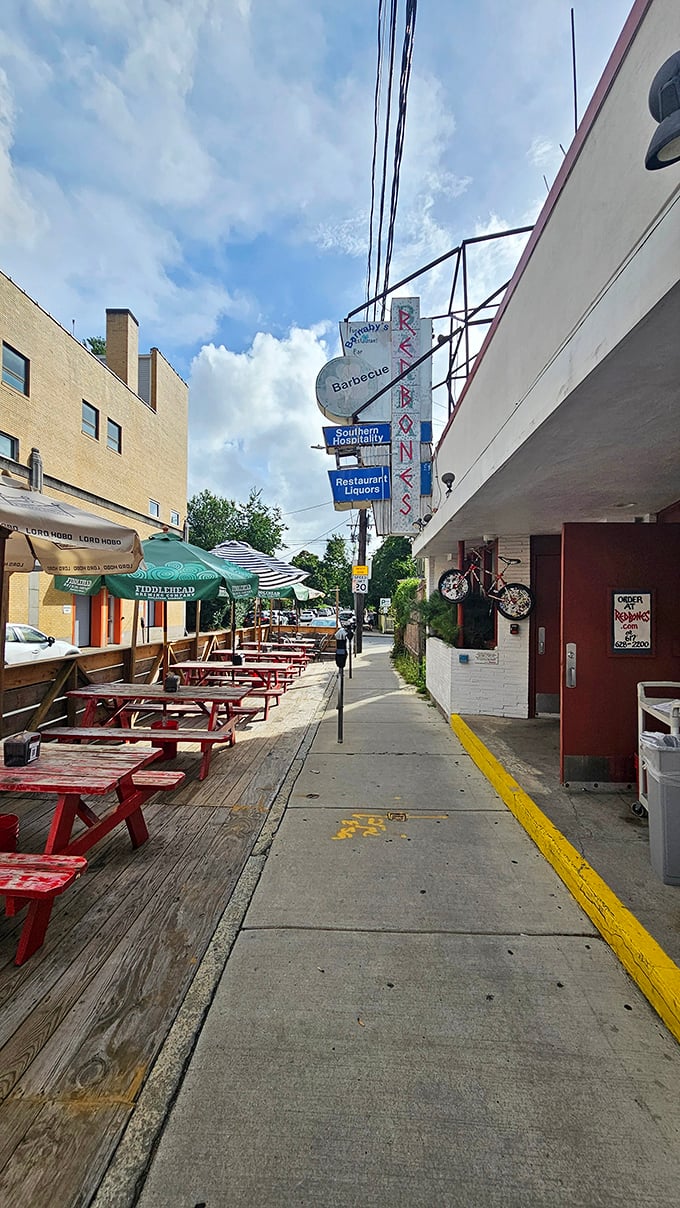 Redbones outdoor seating: Red picnic tables stand ready for the messy symphony of finger-licking and satisfied sighs that define proper BBQ dining.