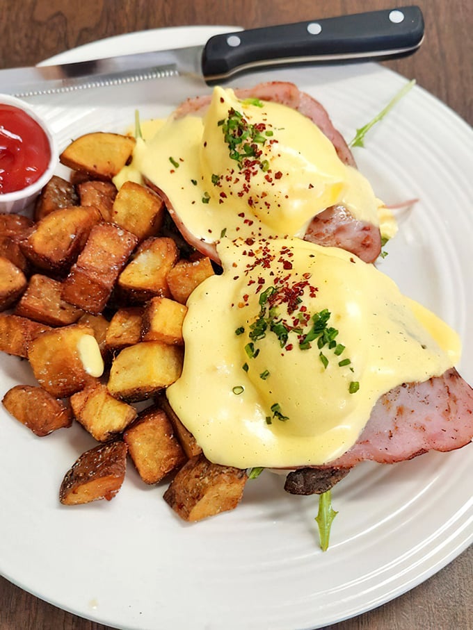 Eggs Benedict reimagined with such care you can practically hear the hollandaise whispering sweet nothings to those perfectly crisped potatoes.