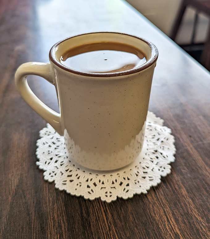 The humble diner coffee mug—delivering life-saving caffeine on a doily, no fancy latte art required. Sometimes simplicity is the ultimate sophistication.