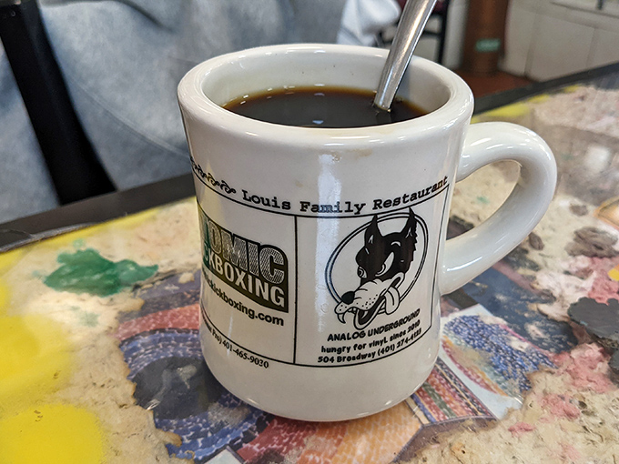 The official morning handshake of Louis Restaurant—a sturdy mug of coffee that means business while showcasing local pride.