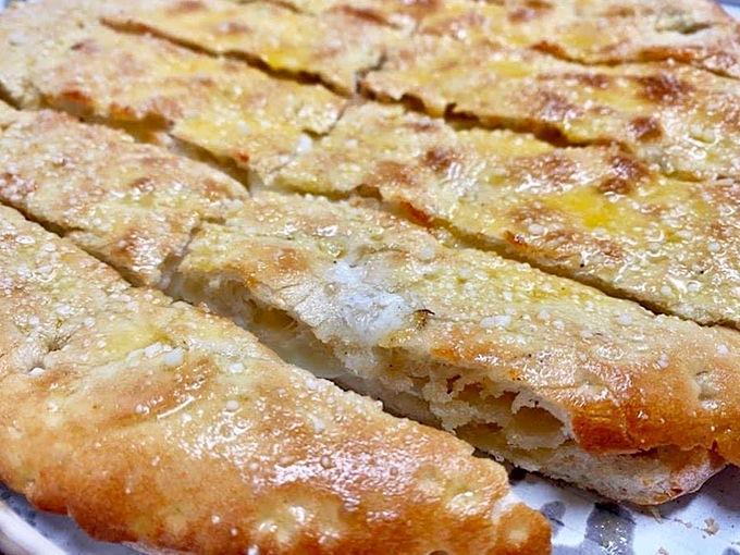 Gio Bread looking like the result of garlic bread and cheese having a beautiful baby that nobody can resist adopting.