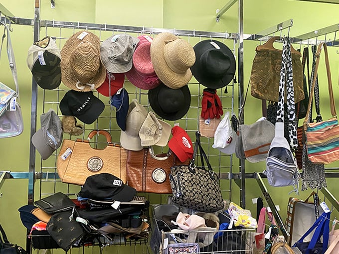 Straw hats, baseball caps, and handbags create an accessories wonderland against that signature green wall.