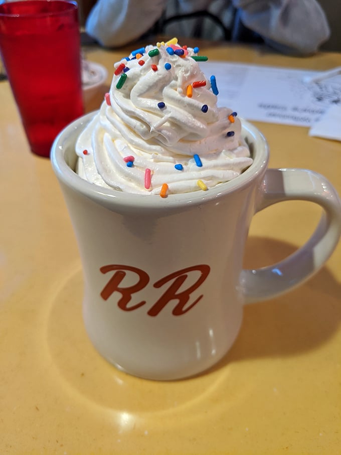 Hot chocolate that's dressed for a celebration, complete with a whipped cream mountain and a confetti of sprinkles.