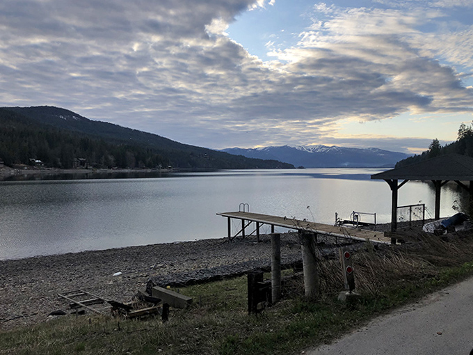 Simple wooden docks extend into the vastness of Lake Pend Oreille as mountains stand sentinel in the distance. Some views don't need Instagram filters.