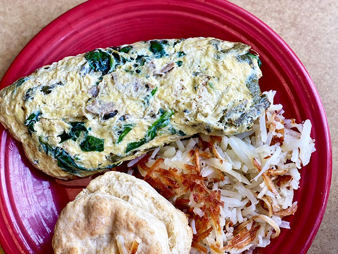 This isn't just an omelet; it's a fluffy yellow envelope delivering good news to your taste buds, with a side of crispy potatoes playing backup.