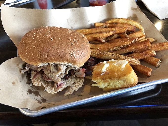 The humble pulled pork sandwich: proof that greatness often comes in simple packages. That cornbread side isn't just a sidekick—it's a co-star.
