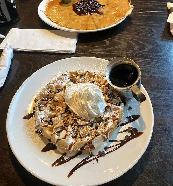 Waffle architecture at its finest&mdash;crispy foundation, cloud-like whipped cream, and chocolate drizzle. Dessert masquerading as breakfast, and nobody's complaining.
