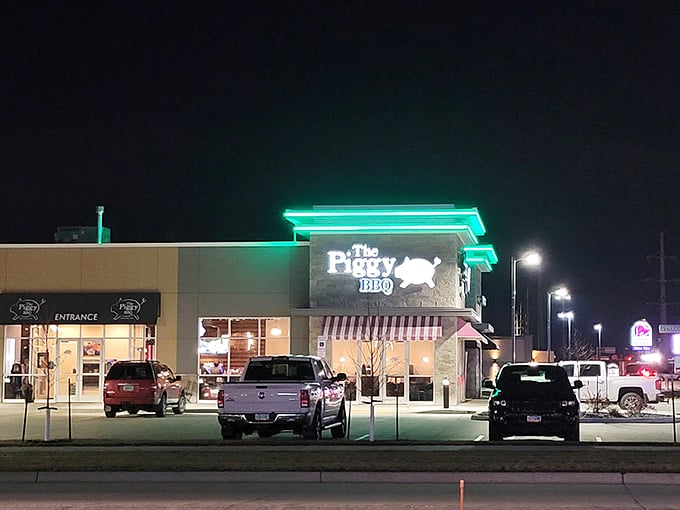 The Piggy BBQ glows like a neon oasis after dark, promising smoky delights that make vegetarians question their life choices.