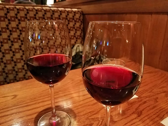 Two glasses of ruby-red wine catch the light, standing ready for that perfect "cheers" moment that turns dinner into an occasion.