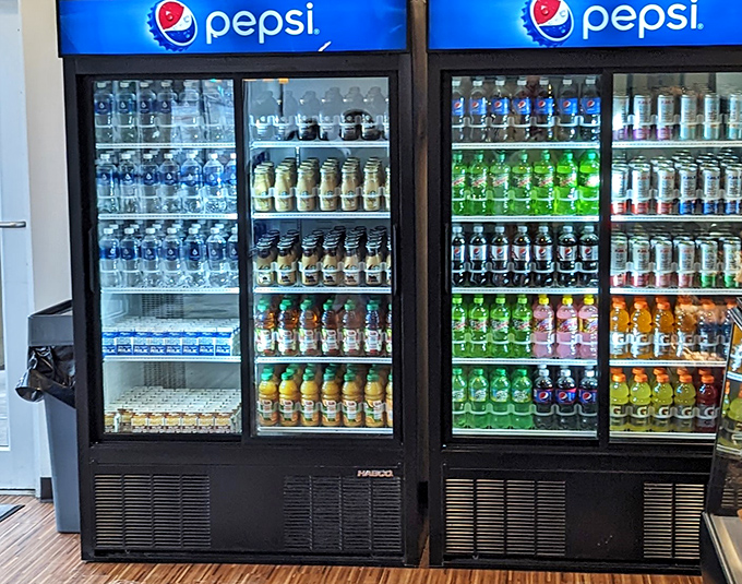 The drink cooler stands ready, offering liquid companions for your pastry adventure. Because every great donut deserves a worthy sidekick.