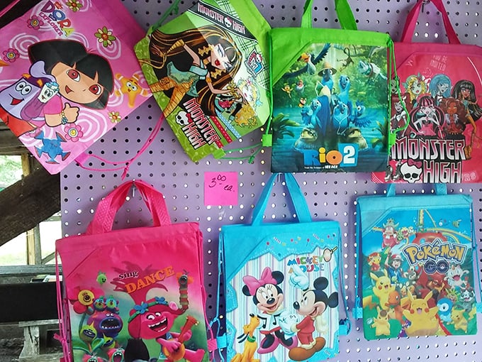 Cartoon character totes hanging like colorful fruit, ripe for the picking. Nostalgia comes in child-sized packages, with handles perfect for tiny adventurers.