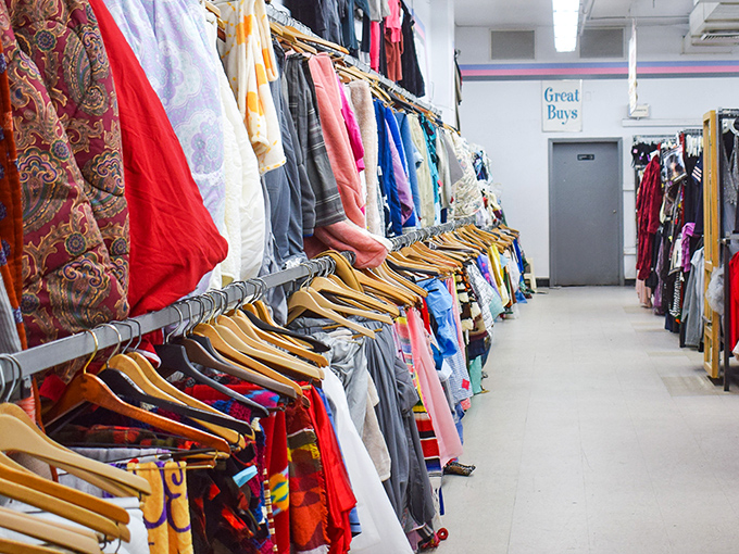 A rainbow of fabrics tells a thousand stories—each hanger holding someone's former favorite shirt, now waiting for its second act in someone else's wardrobe.