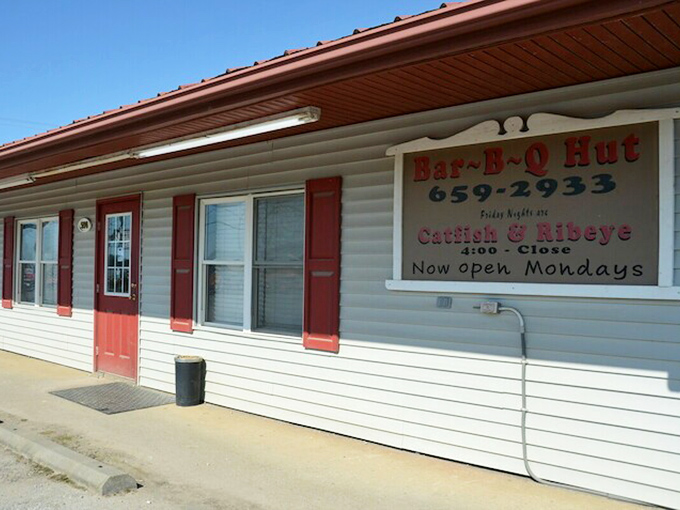 Bar-B-Q Hut's simple white siding and red shutters look like a dollhouse that grew up and found its true calling in smoke.
