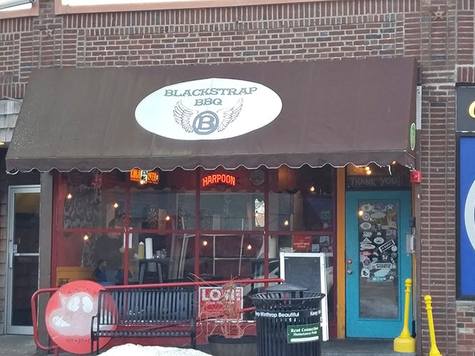 Blackstrap BBQ storefront: Behind this modest brick fa&ccedil;ade with brown awning lies a world where smoke and time transform the ordinary into extraordinary.