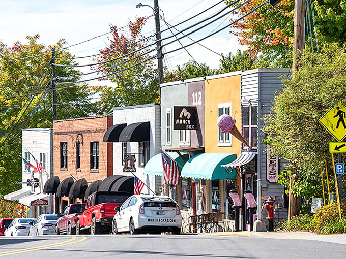 Colorful storefronts line Burnsville's charming main street, where autumn leaves and striped awnings create a perfect small-town shopping scene.