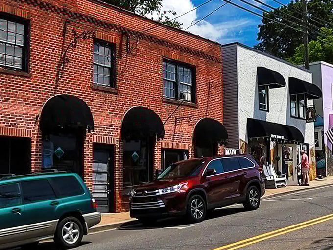 Historic brick storefronts line Burnsville's charming main street, where black awnings create inviting shadows on a sunny North Carolina afternoon.