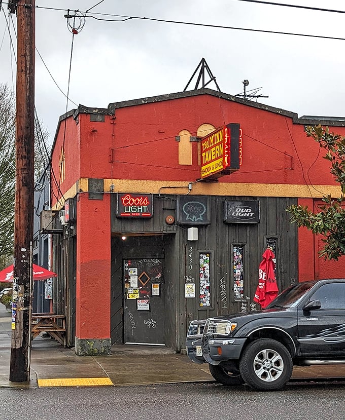 The tavern's weathered red exterior tells stories. Inside this unassuming corner spot, chicken dreams come true.