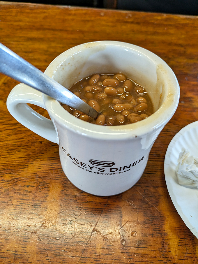 A mug of baked beans &ndash; the unsung hero of diner sides, swimming in a sweet-savory sauce that would make Boston proud.