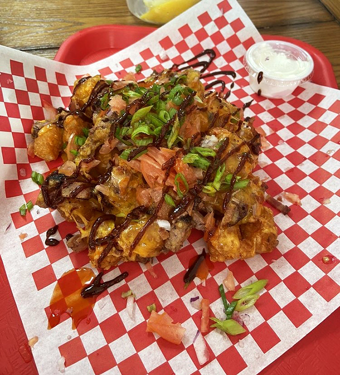 Tater tots elevated to an art form&mdash;crispy potato nuggets crowned with brisket, green onions, and sauce that makes you question all other potato preparations.