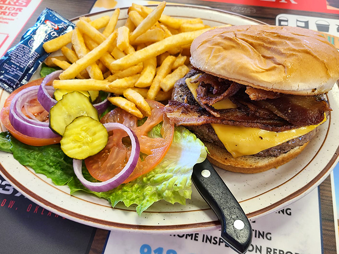 A burger that requires both hands and a strategy, flanked by fresh veggies that didn't come from some distant distribution center yesterday.