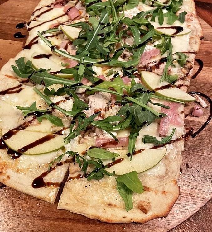 This flatbread is what happens when pizza goes to finishing school – arugula and apple slices dancing atop melted cheese like sophisticated party guests.