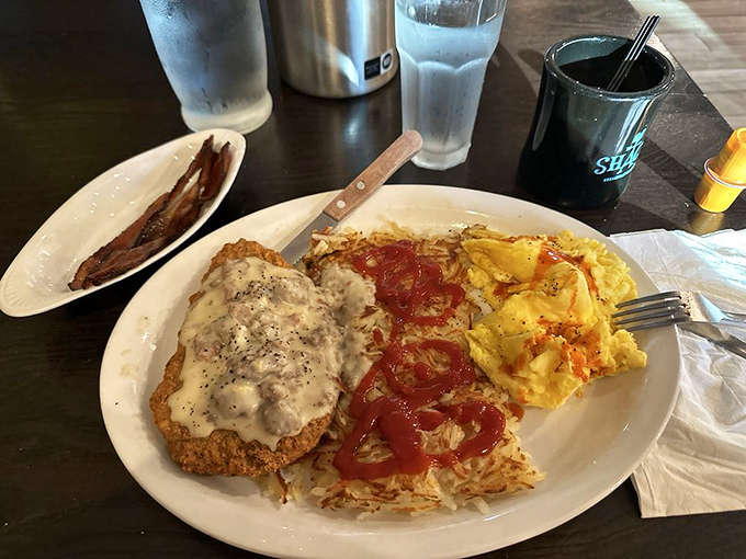 Country fried steak smothered in gravy alongside eggs and hash browns. The breakfast trifecta that makes you want to buy a cowboy hat in gratitude.