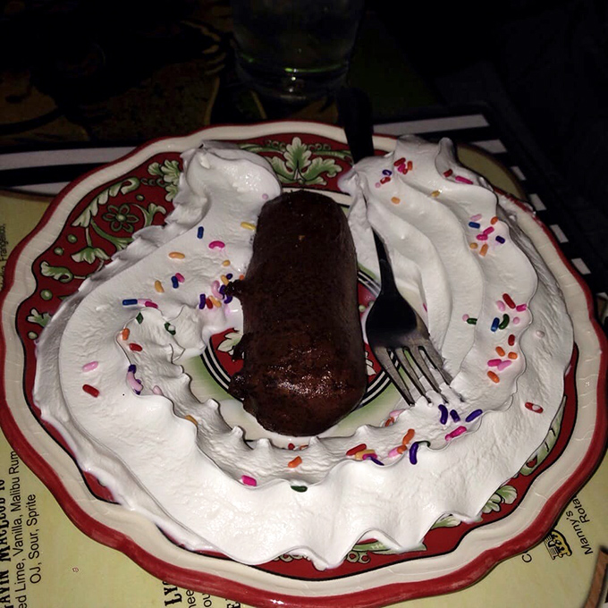 A chocolate dessert surrounded by whipped cream and sprinkles that makes you wonder why grown-up desserts can't always be this fun.