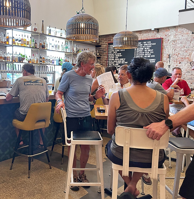 The bustling bar area captures that perfect moment when strangers become temporary friends, united by the universal language of great barbecue.