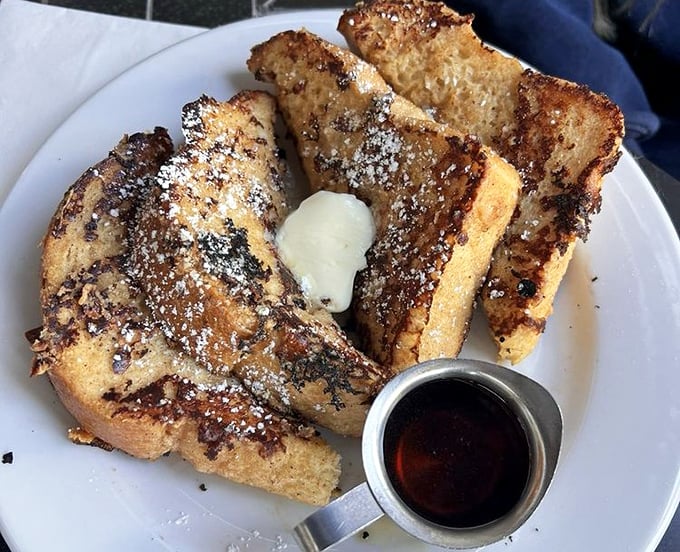 French toast transformed into an art form—thick-cut bread with a caramelized exterior, dusted with powdered sugar and waiting for that maple syrup baptism.