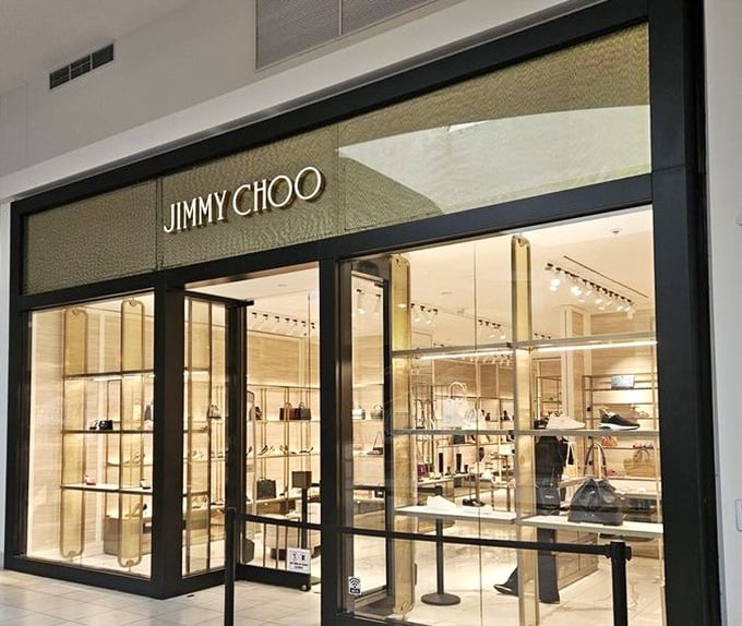 Jimmy Choo's storefront gleams with possibility—where Cinderella stories begin with 40% off and end with "I deserved this."
