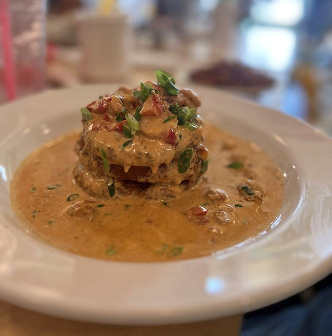 These stacked fried green tomatoes swimming in creamy sauce aren't just a dish—they're edible Southern poetry on a plate.