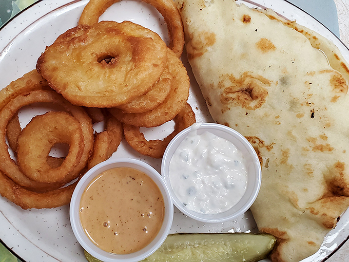 Onion rings with perfect golden halos alongside what appears to be a quesadilla. Comfort food that speaks a universal language.