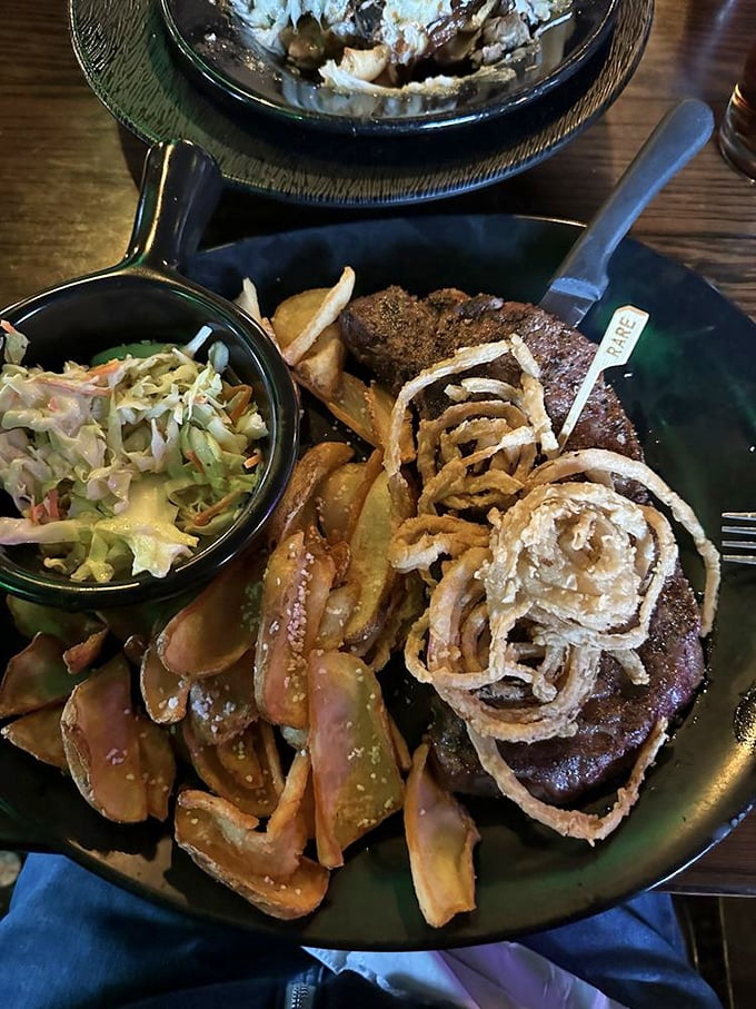 A steak dinner that means business, complete with crispy onion straws, house-made slaw, and chips that refuse to be upstaged.
