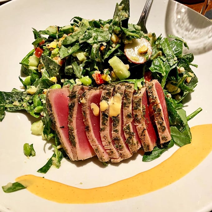 Seared tuna that's ruby-red inside and perfectly seasoned outside, resting on a bed of greens that actually deserve to be eaten, not pushed aside.
