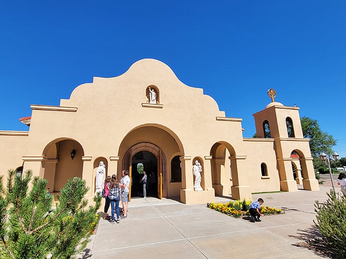 St. Peter's Catholic Church welcomes visitors with mission-style grace, its warm adobe walls glowing like sunset against Arizona's brilliant blue sky.