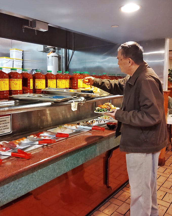 A patron carefully selects his next culinary adventure, surrounded by bottles of that magical red sauce that makes everything taste better.