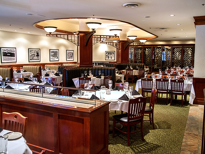 The dining room where white tablecloths meet baseball nostalgia. Notice how everyone sits a little taller when surrounded by such elegant comfort.