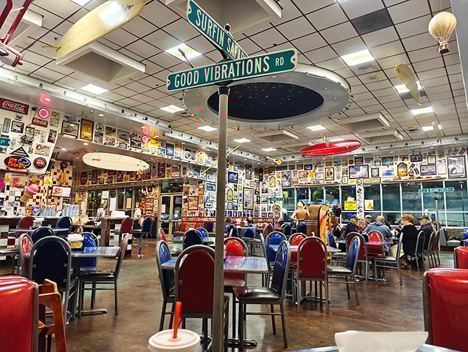 Street signs reading "Surfin' Safari" and "Good Vibrations" hang above diners, creating a Beach Boys soundtrack even in complete silence.