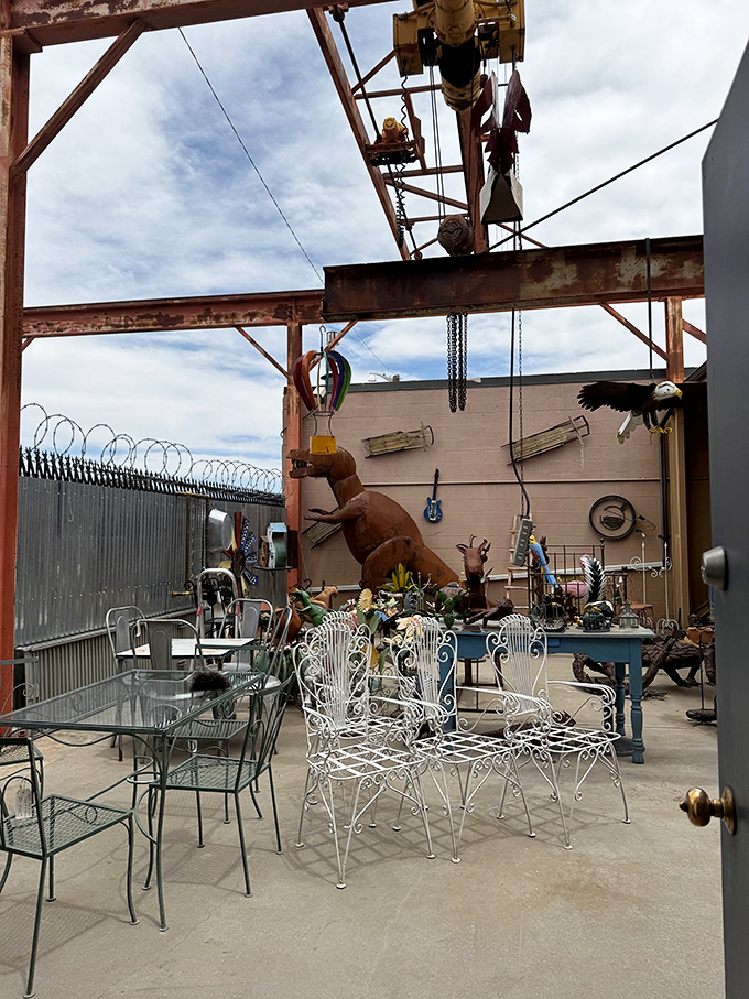 Rusty dinosaurs and wrought iron chairs create an outdoor seating area where Mad Max might host a surprisingly civilized afternoon tea.