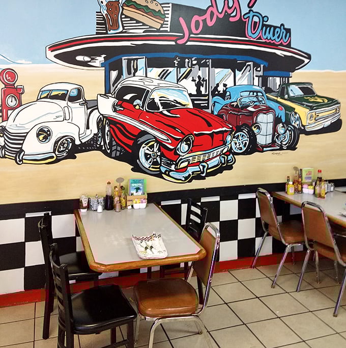 Classic Americana comes alive on this mural wall, where vintage cars gather at an idealized diner – nostalgia you can eat with.