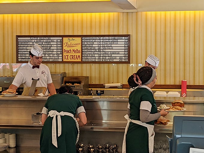 The staff moves with choreographed precision, their classic uniforms a nod to an era when service was an art form, not just a job.