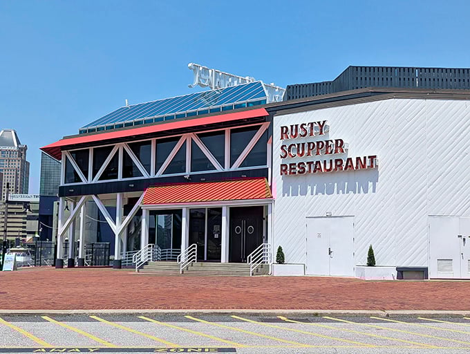 The Rusty Scupper's distinctive waterfront building stands proudly against Baltimore's skyline, promising amazing seafood and harbor views inside.