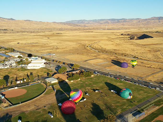 Colorful hot air balloons prepare for launch near Coalinga, offering affordable entertainment against the backdrop of California's golden hills.