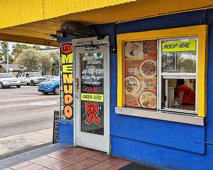 The vibrant blue and yellow exterior of El Norteño beckons like a colorful oasis in the desert, complete with a menu board that promises authentic Mexican delights.