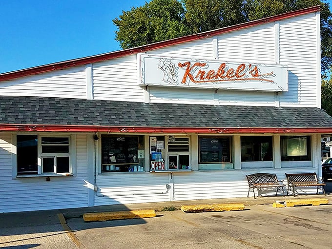 The classic white clapboard exterior of Krekel's stands like a time capsule of Americana, complete with vintage signage and welcoming benches for post-burger contemplation.